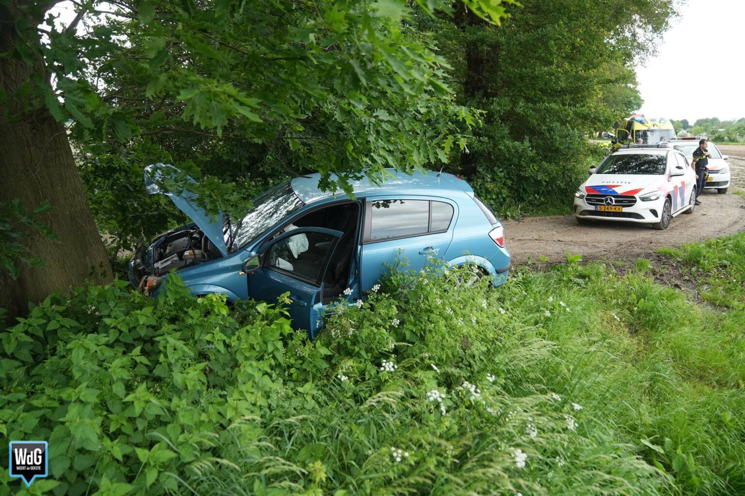 Auto tegen boom naast landweg in Baexem